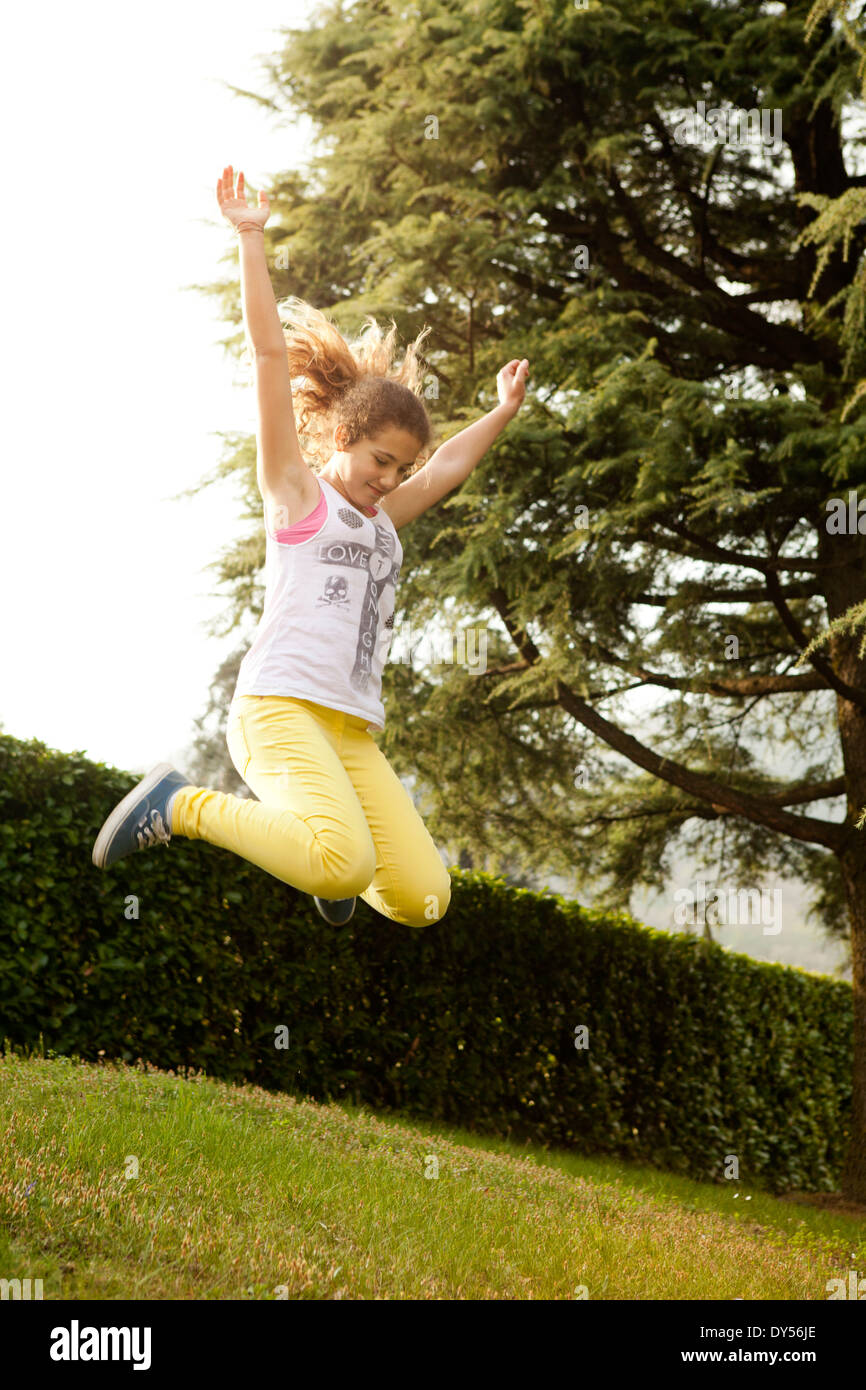 Young girl jumping high in the garden Stock Photo - Alamy