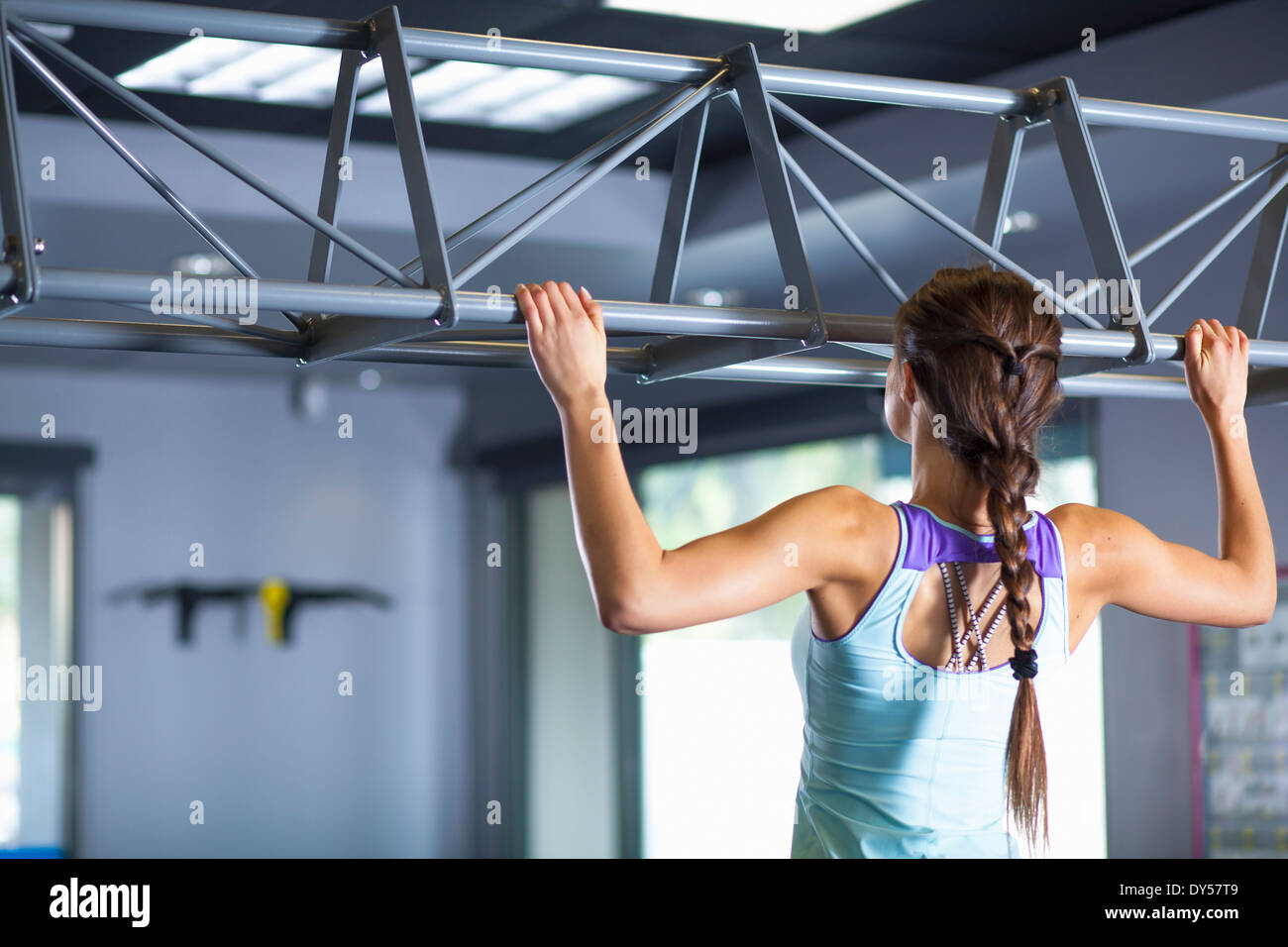 Rear view of a sporty young woman stretching hands at yoga class in ...