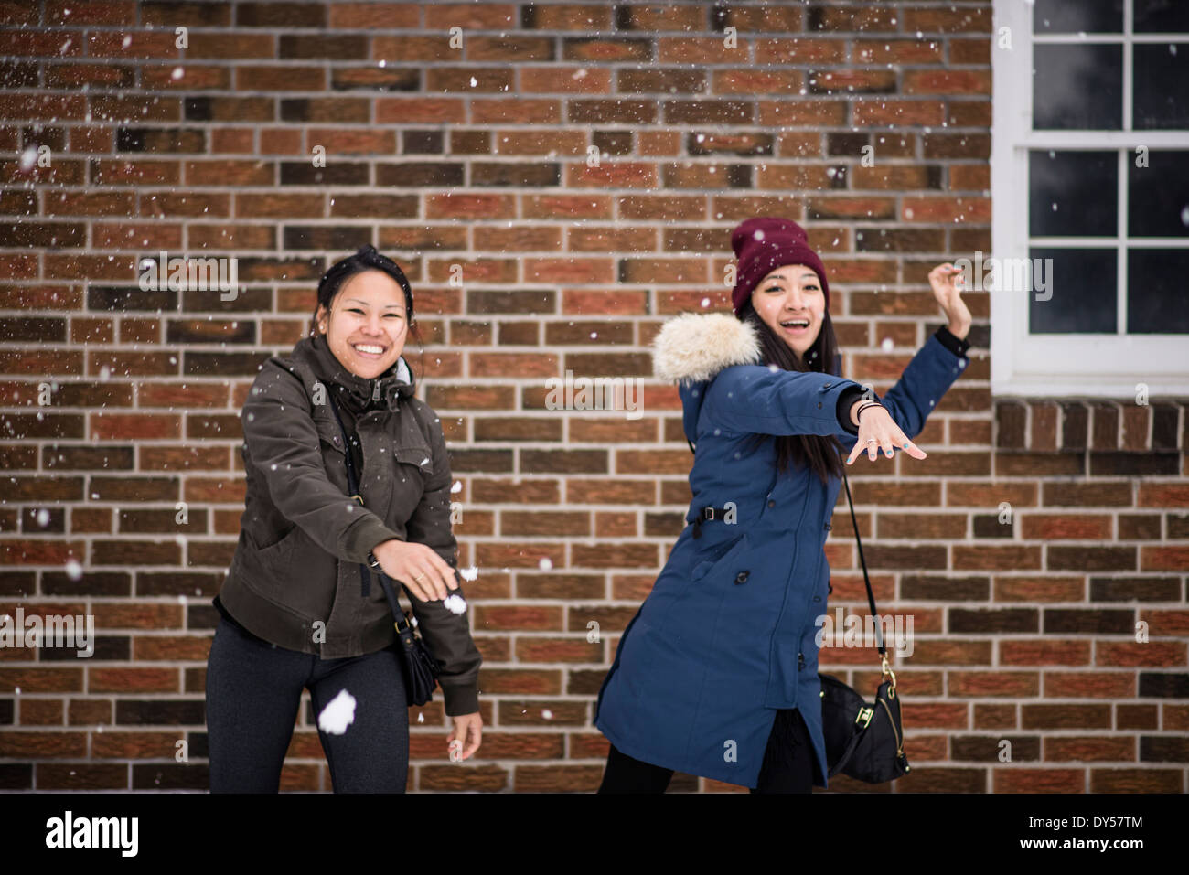 Two you adult females throwing snowballs Stock Photo - Alamy