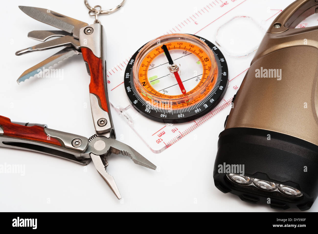 Knife with pliers, a compass and an electric torch Stock Photo - Alamy