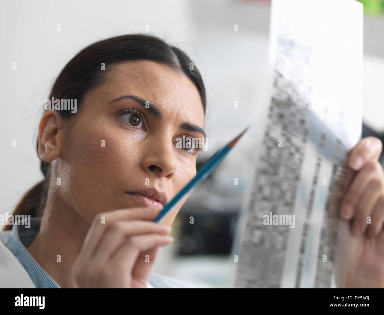 Female scientist examining DNA gel in laboratory for genetic research ...