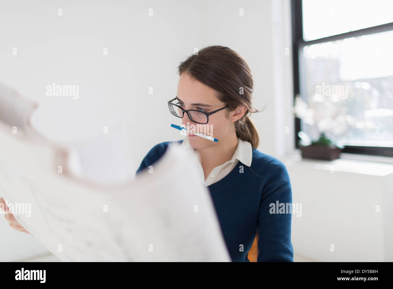 Young woman studying blueprint Stock Photo - Alamy