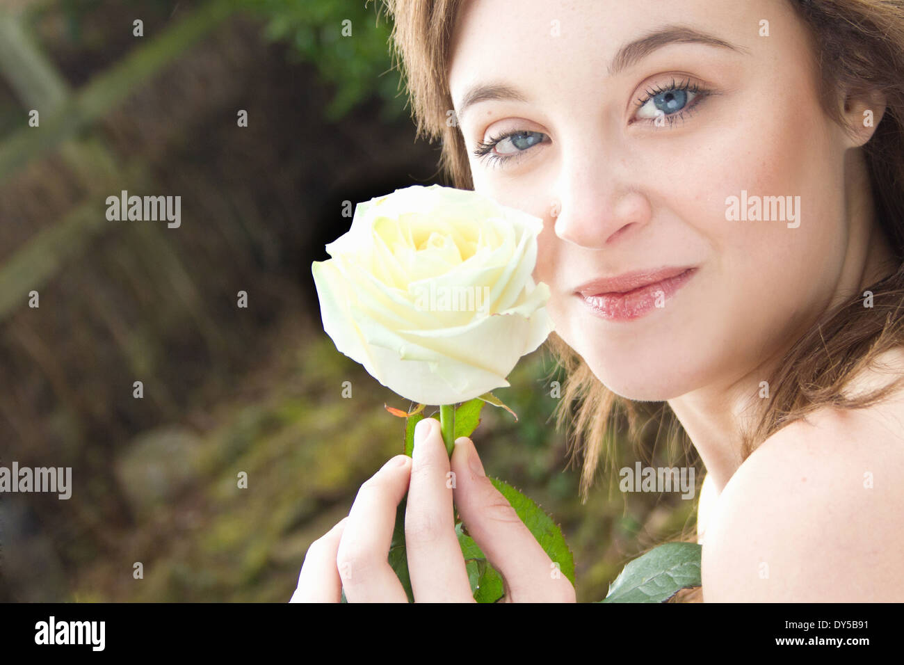 Portrait of young woman holding a rose Stock Photo - Alamy