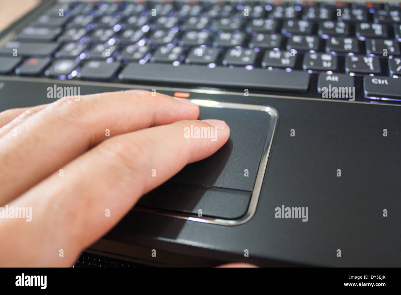 a hand is touching the laptop touchpad Stock Photo - Alamy