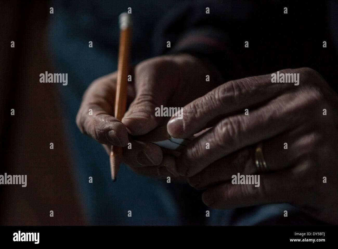 Close up of male hands holding a pencil and piece of wood Stock Photo ...