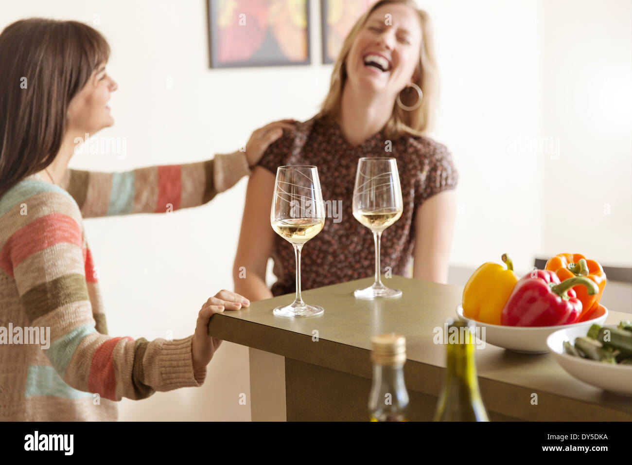 Mid adult female friends laughing in kitchen Stock Photo - Alamy