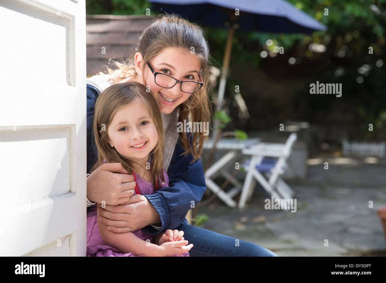 Girl hugging sister in garden Stock Photo - Alamy