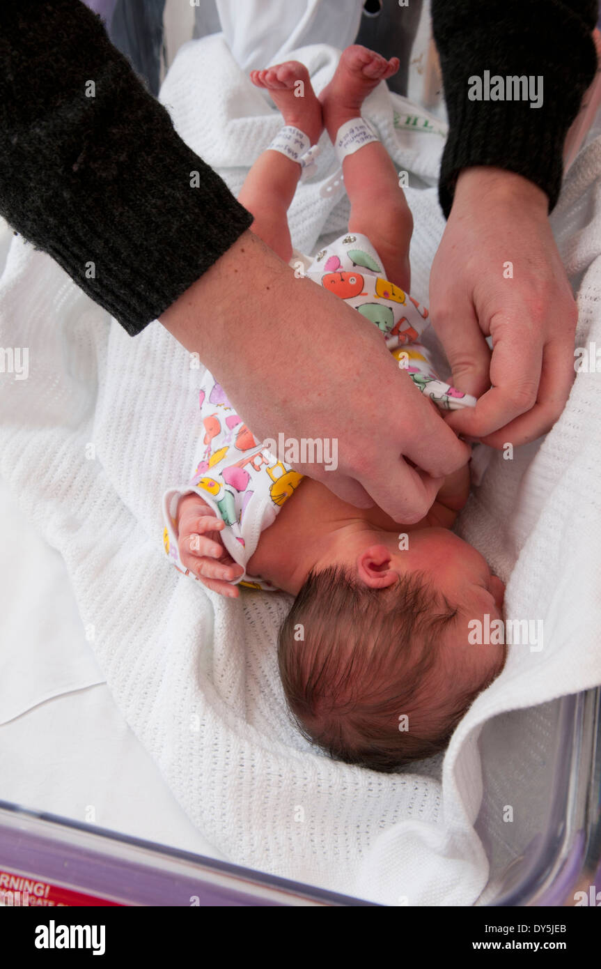 Newborn baby girl being dressed for the first time by her father Stock ...