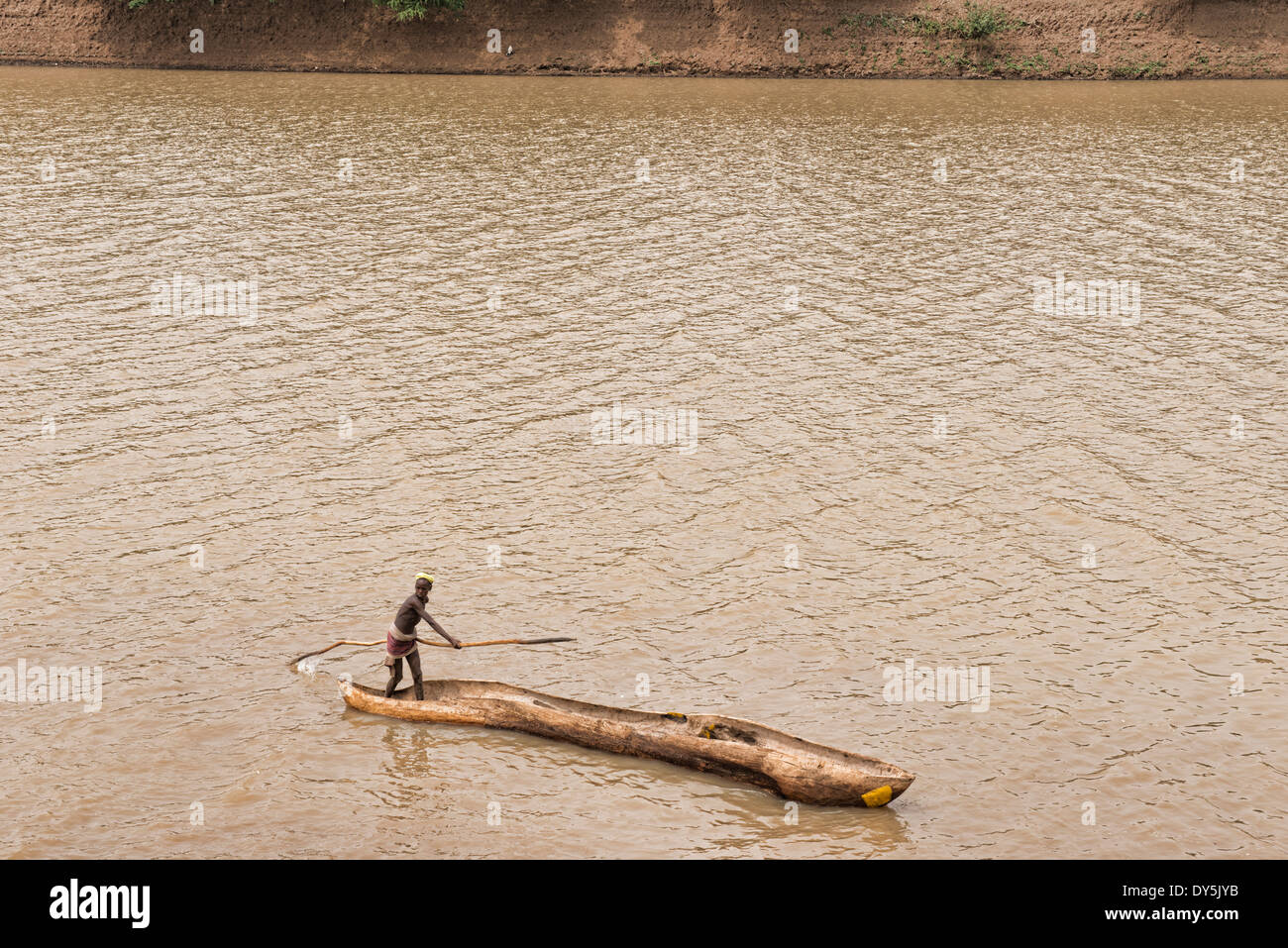 Dassanech man rowing his dugout canoe on the Omo River in the Lower Omo ...