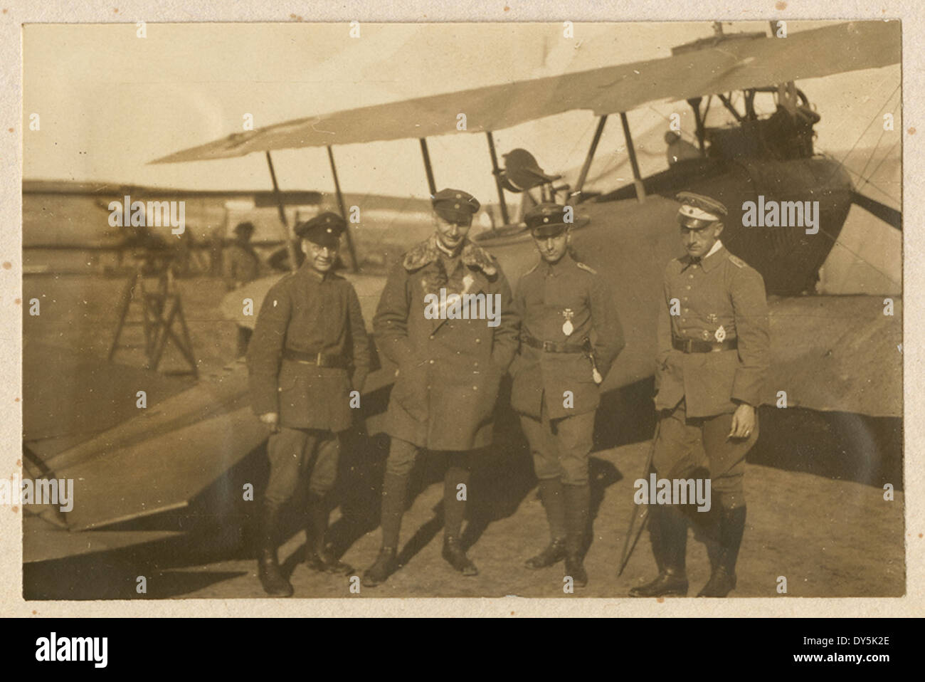 Four German pilots pose in front of a biplane during World War I in ...