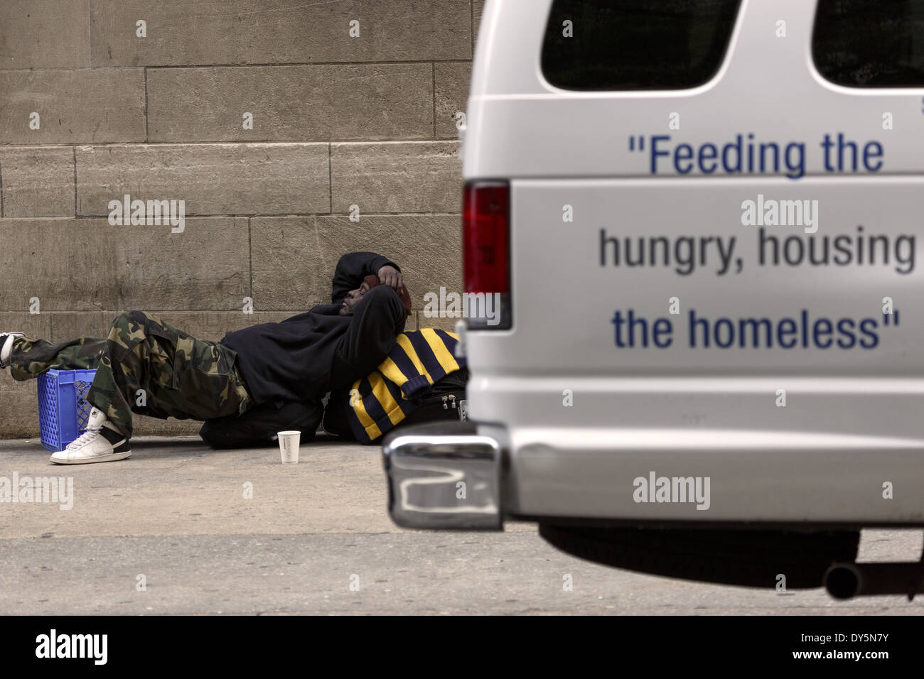 Black male laying on the sidewalk and van with the words feeding the ...