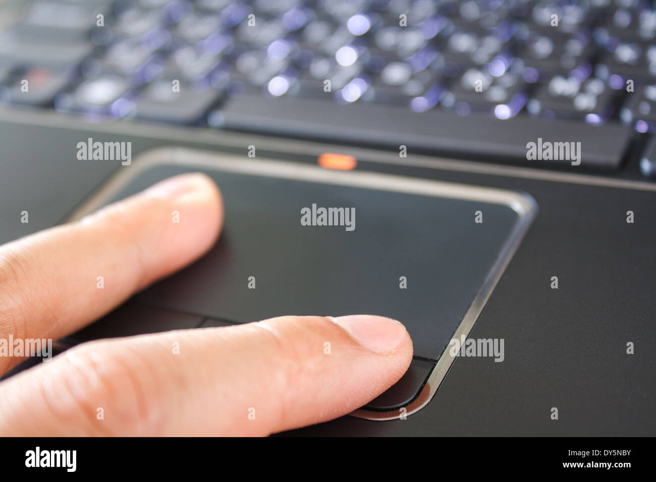 a hand is touching the laptop touchpad Stock Photo - Alamy