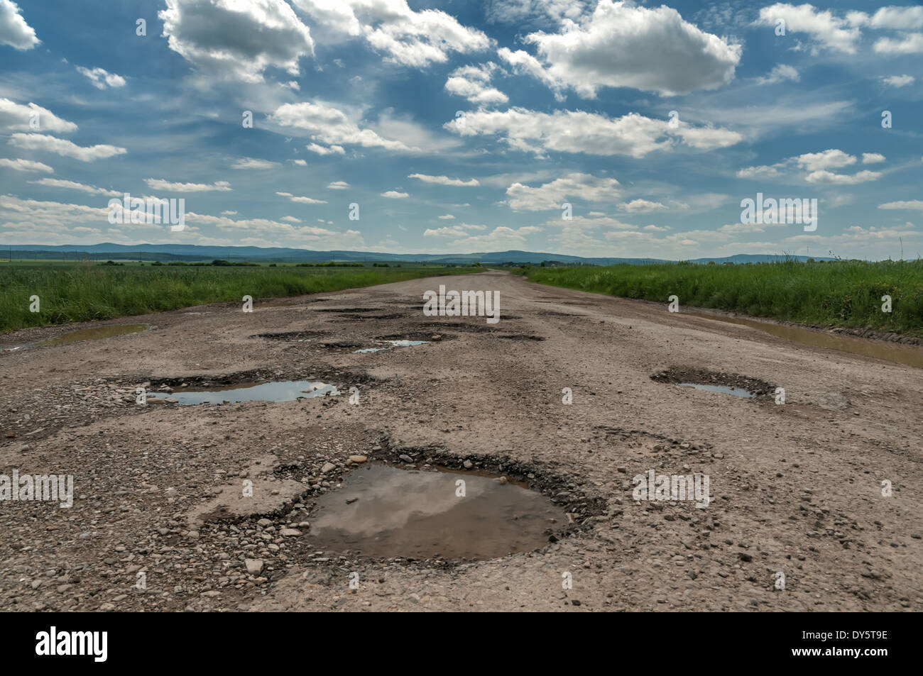 puddle on old cracked road Stock Photo - Alamy