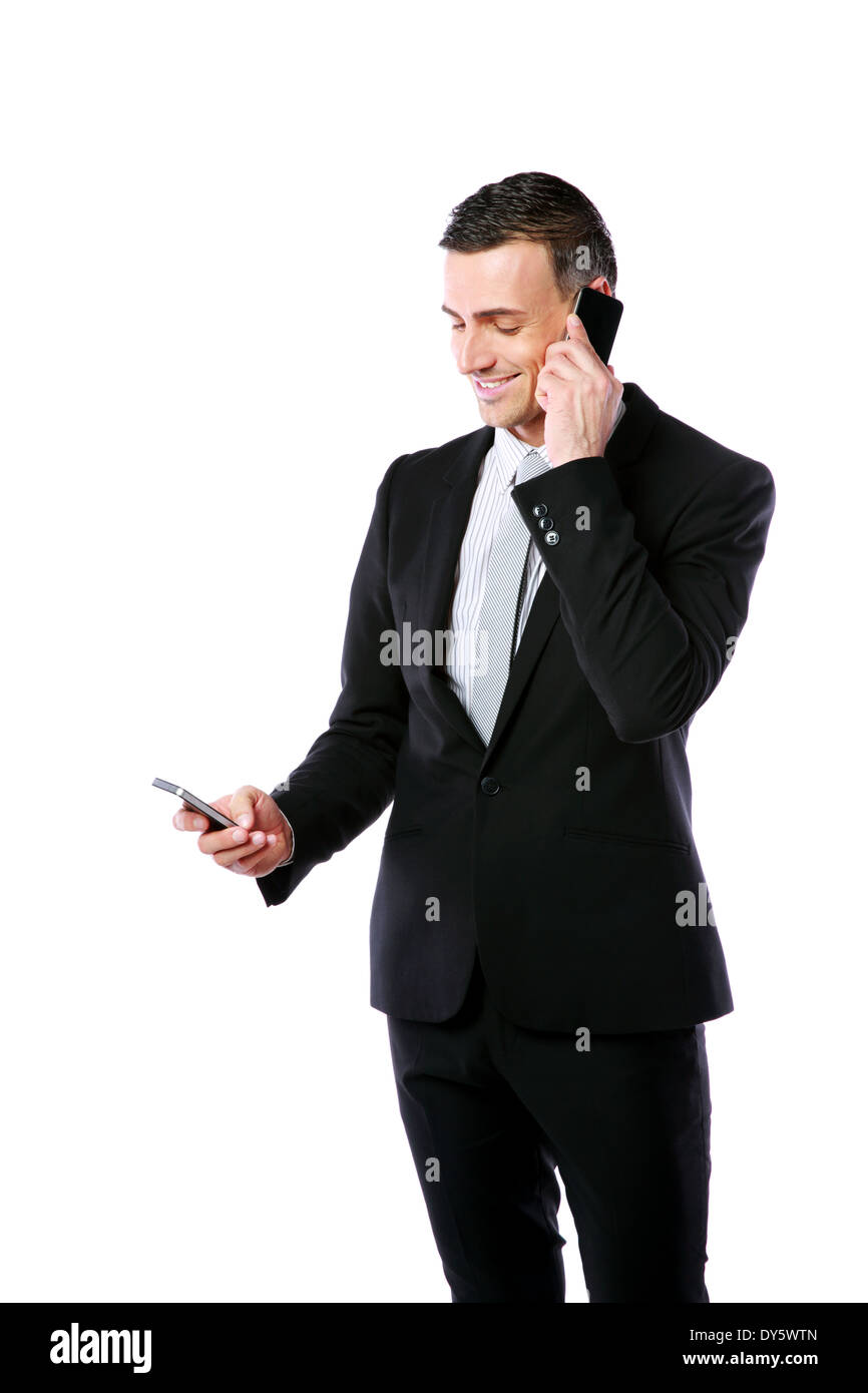 Happy busy businessman using two mobile phone over white background ...