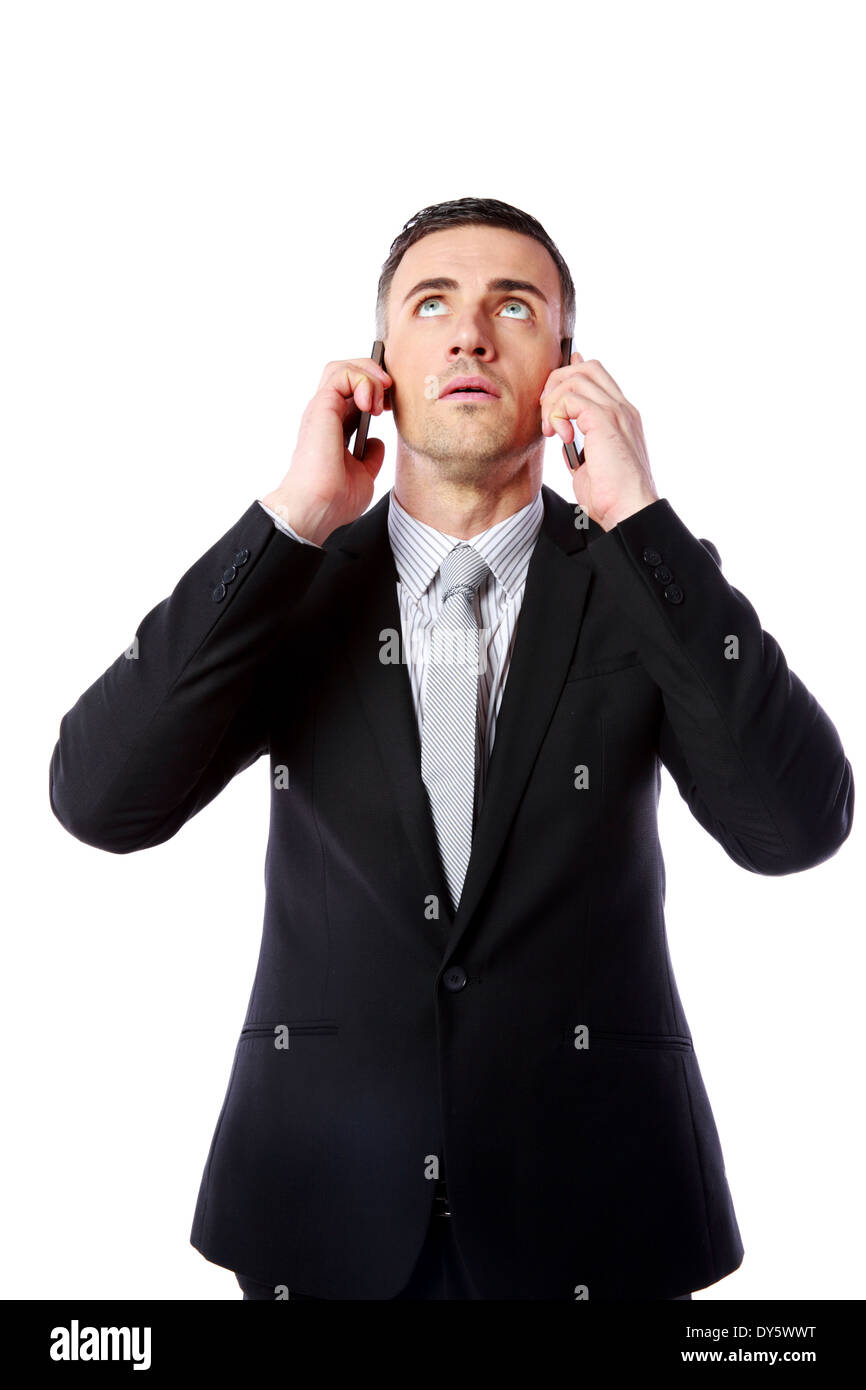Businessman talking on two cell phones at the same time over white ...