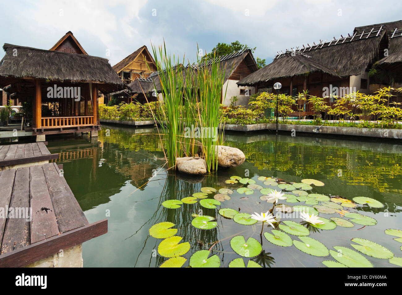 Traditional kampung style rooms over carp ponds at the Kampung Sumber ...