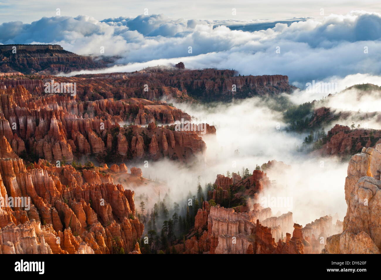 Pinnacles and hoodoos with fog extending into clouds of a partial ...