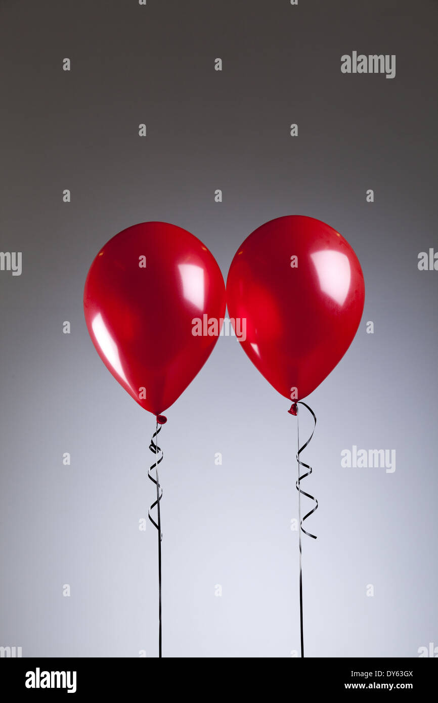 Shiny Red Balloons on a grey background Stock Photo - Alamy