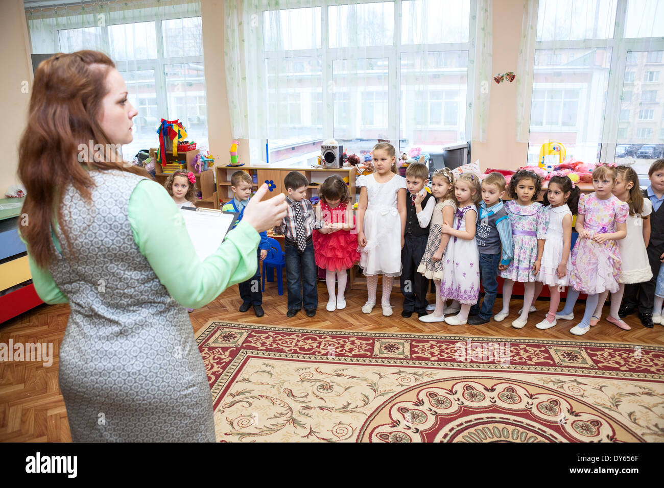 Boys and girls dance waltz in pairs on theater stage in kindergarten ...