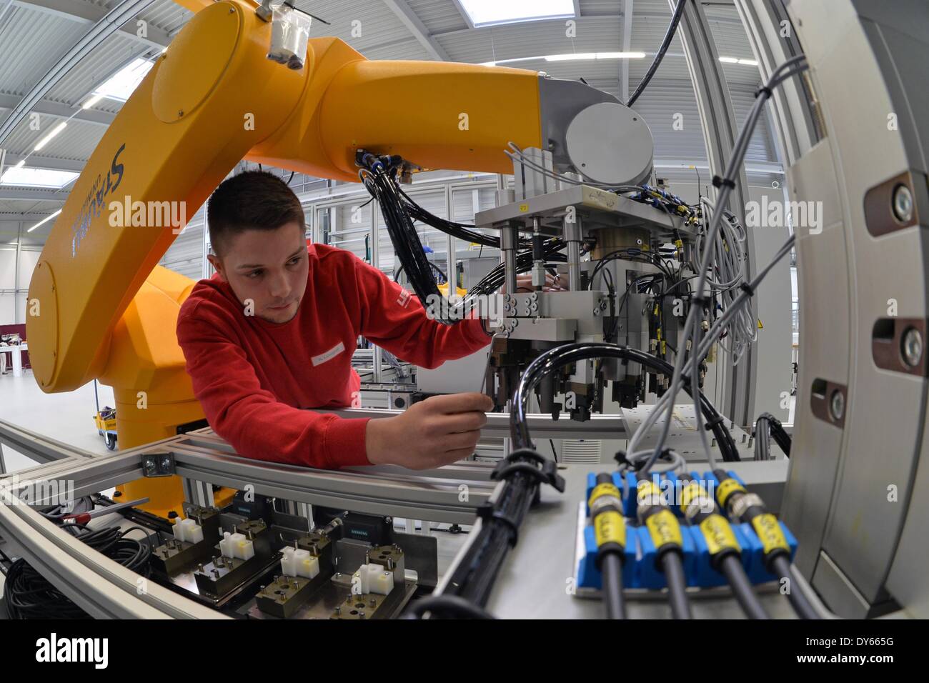 Industrial mechanic Kevin Landgraf installs the arm of a robot at the ...