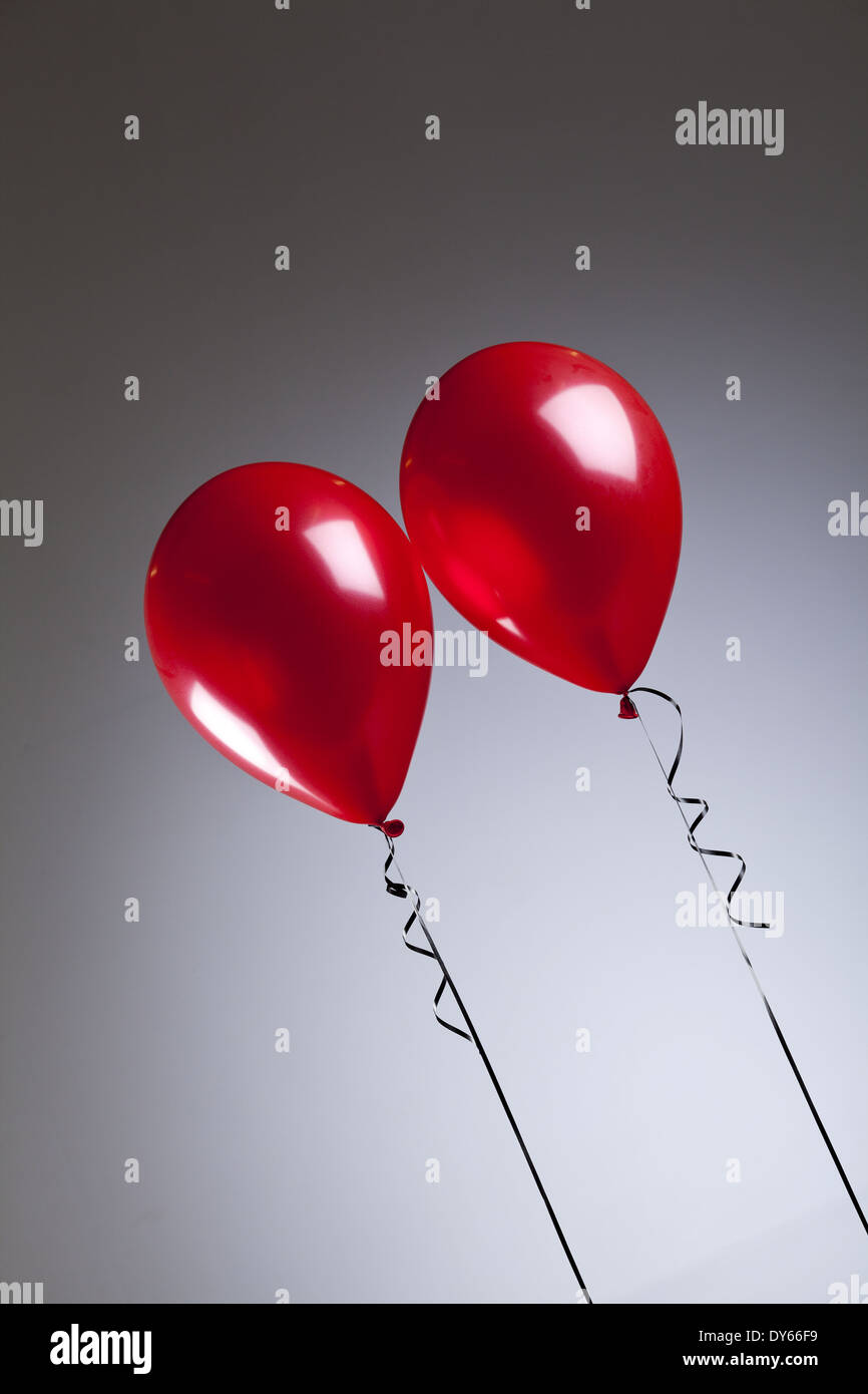 Shiny Red Balloons on a grey background Stock Photo - Alamy