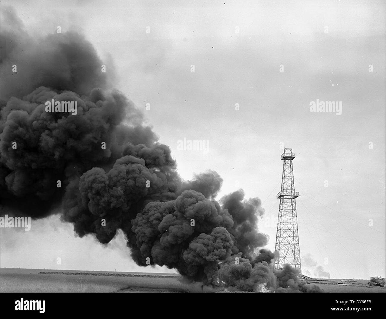 The image depicts an oil well fire in Texas, with smoke billowing from ...