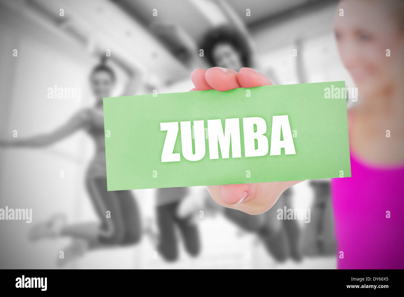 Zumba against fit blonde holding pink card Stock Photo - Alamy
