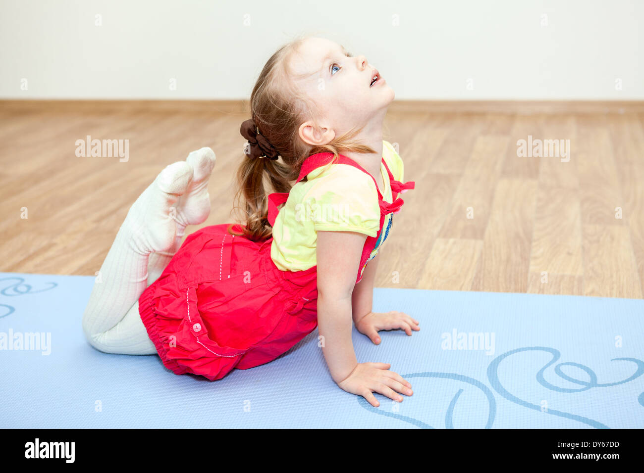 Small Caucasian girl making yoga pose on mat in gym Stock Photo - Alamy