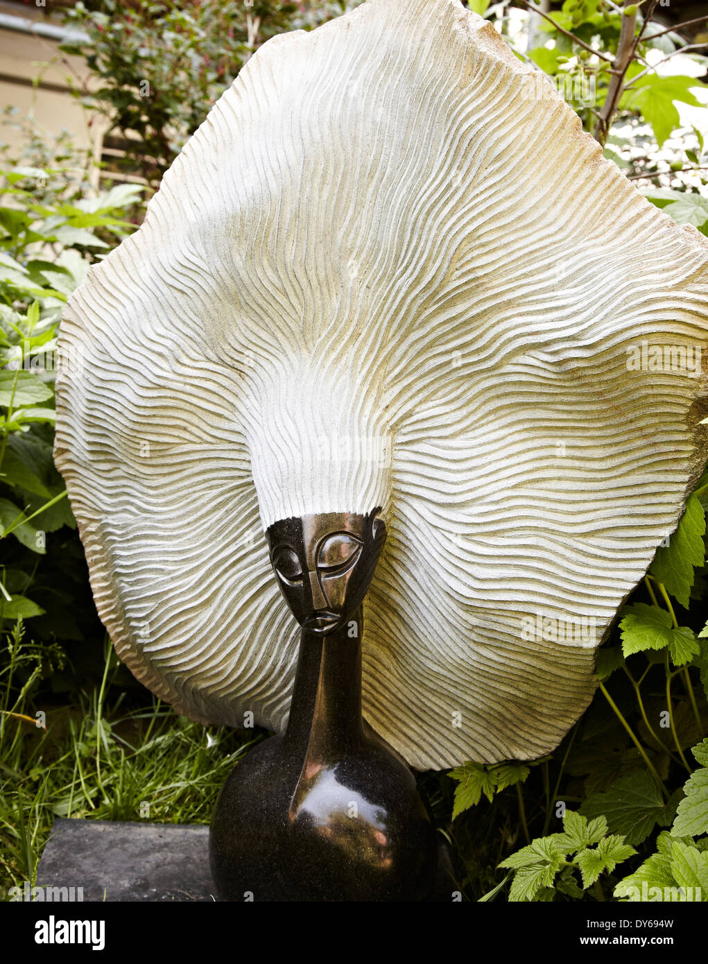 an African style grey sculpture in a garden Stock Photo - Alamy