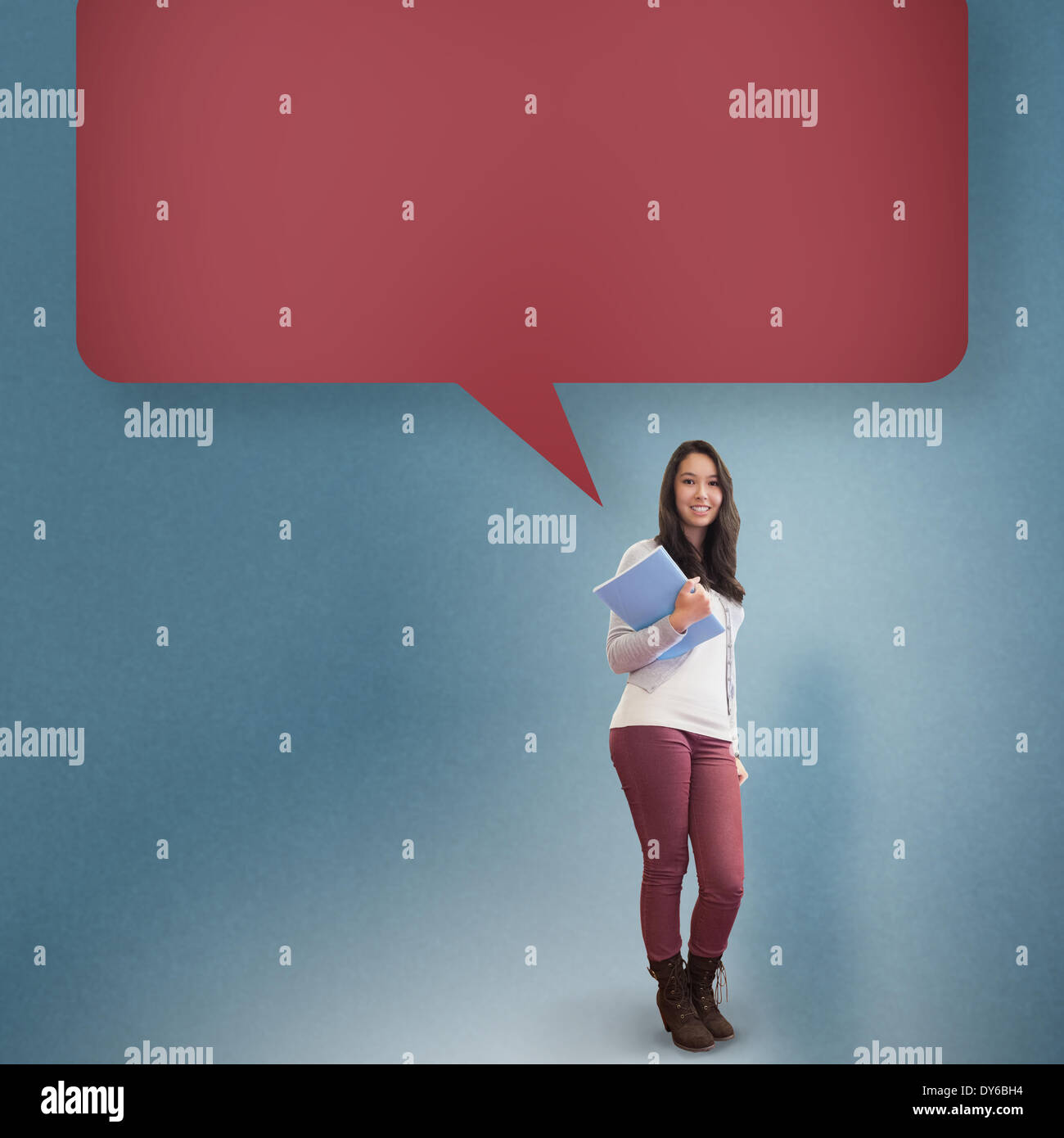 Composite image of smiling student holding textbook with speech bubble ...