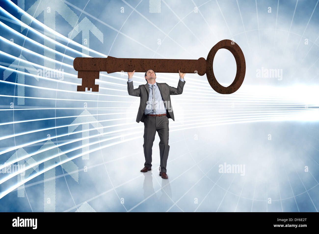 Businessman carrying large key with arms raised against arrow door in ...