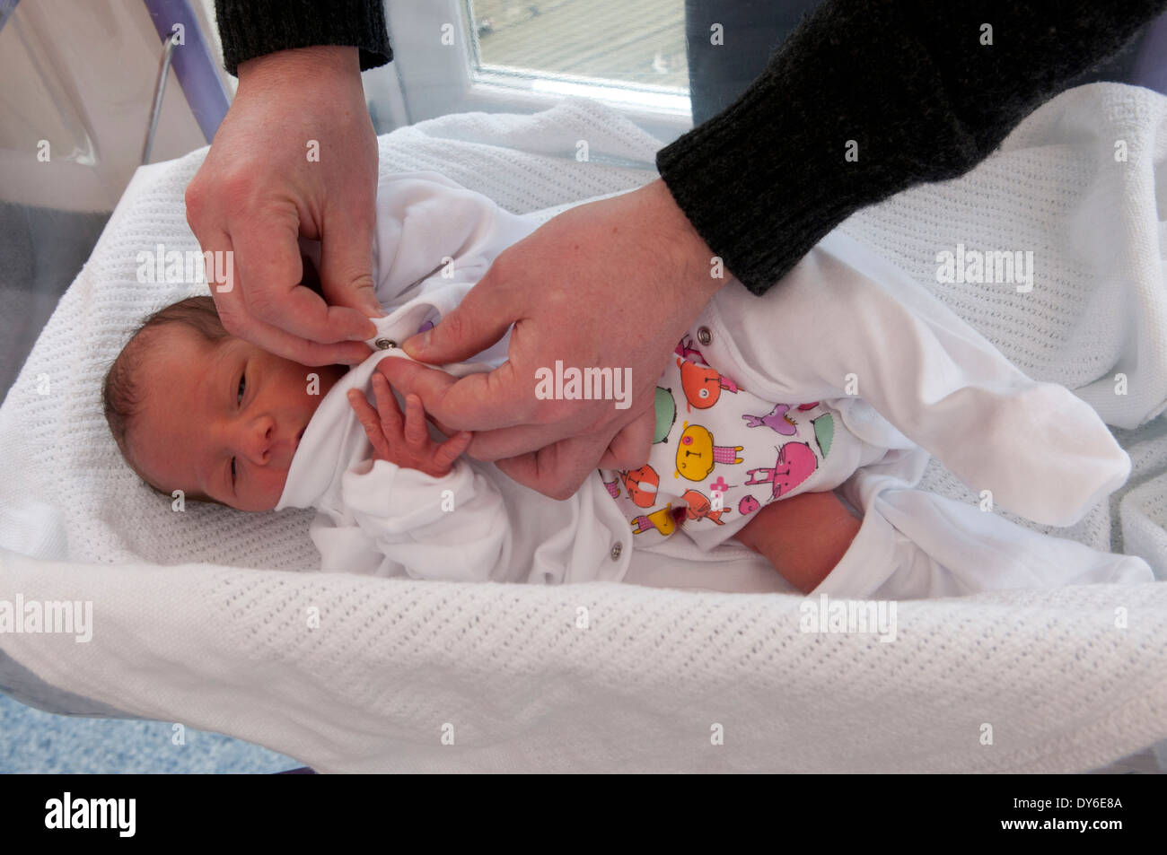 Newborn baby girl being dressed for the first time by her father Stock ...