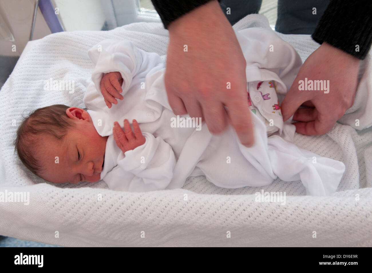 Newborn baby girl being dressed for the first time by her father Stock ...