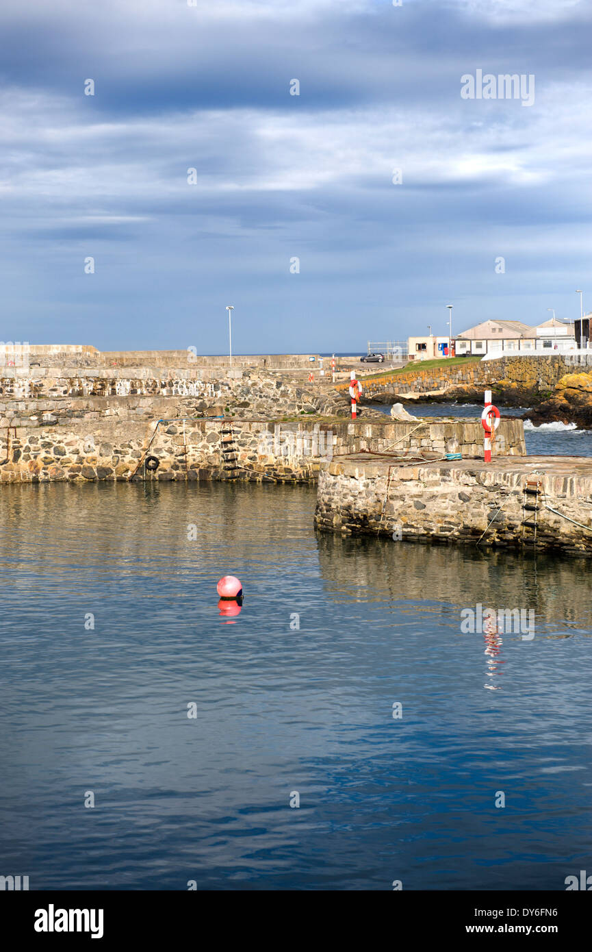 The breakwater and quay at the harbour in the village of Portsoy on the ...