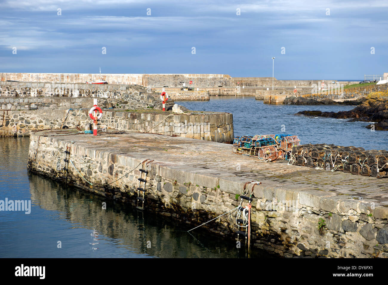 The breakwater and quay at the harbour in the village of Portsoy on the ...