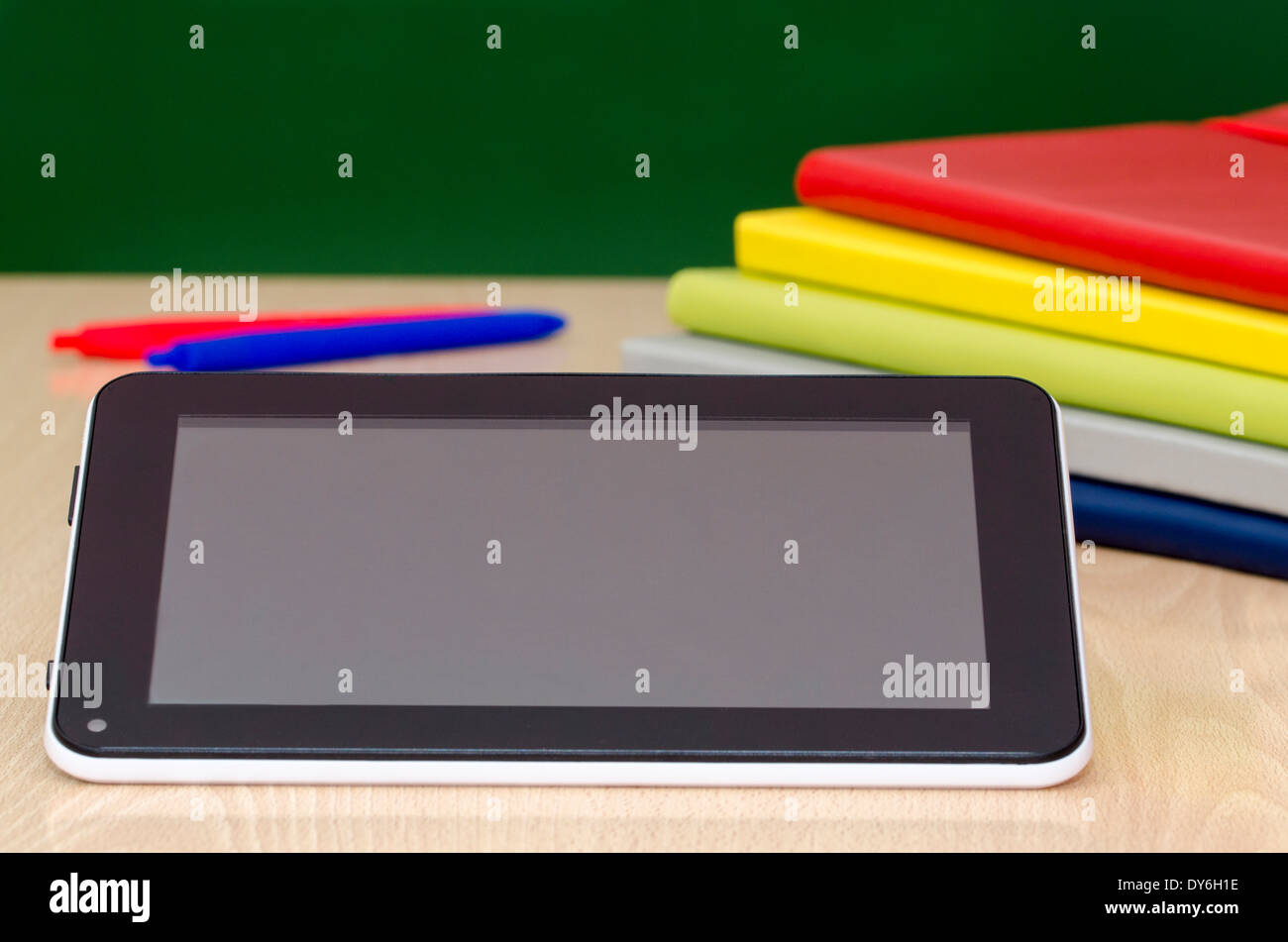 digital tablet leaning against a colorful notebooks,on a school desk ...