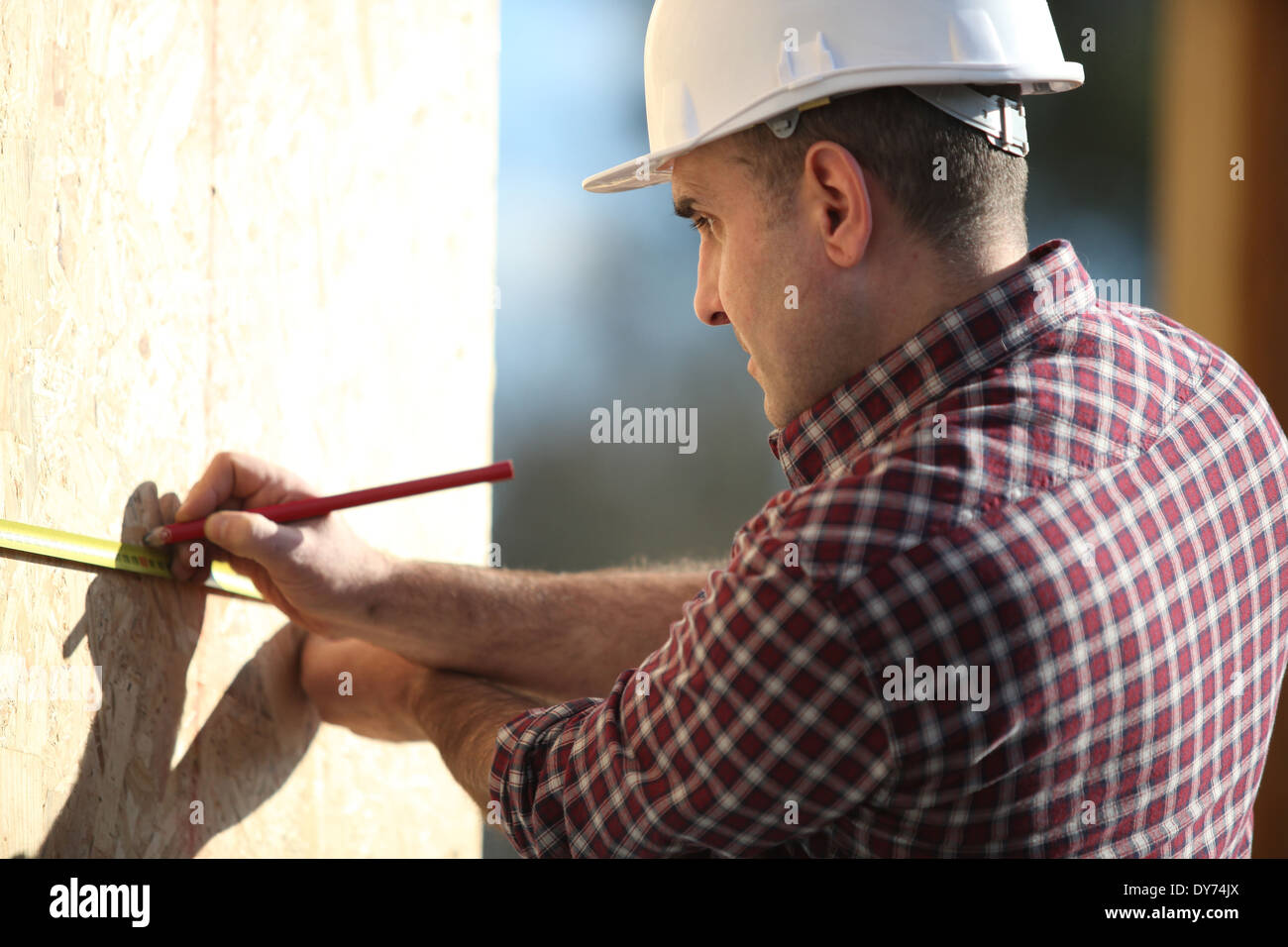 Construction worker marking wooden frame Stock Photo - Alamy