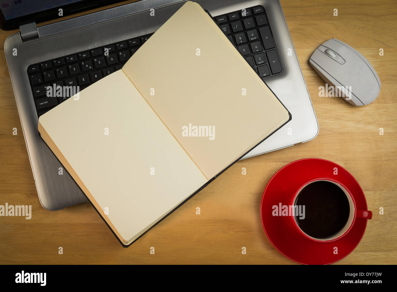 Overhead of open notebook on laptop Stock Photo - Alamy