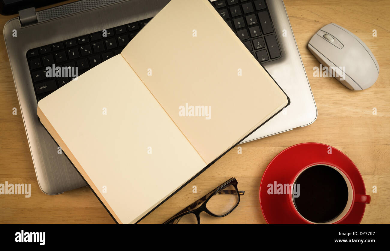 Overhead of open notebook on laptop Stock Photo - Alamy