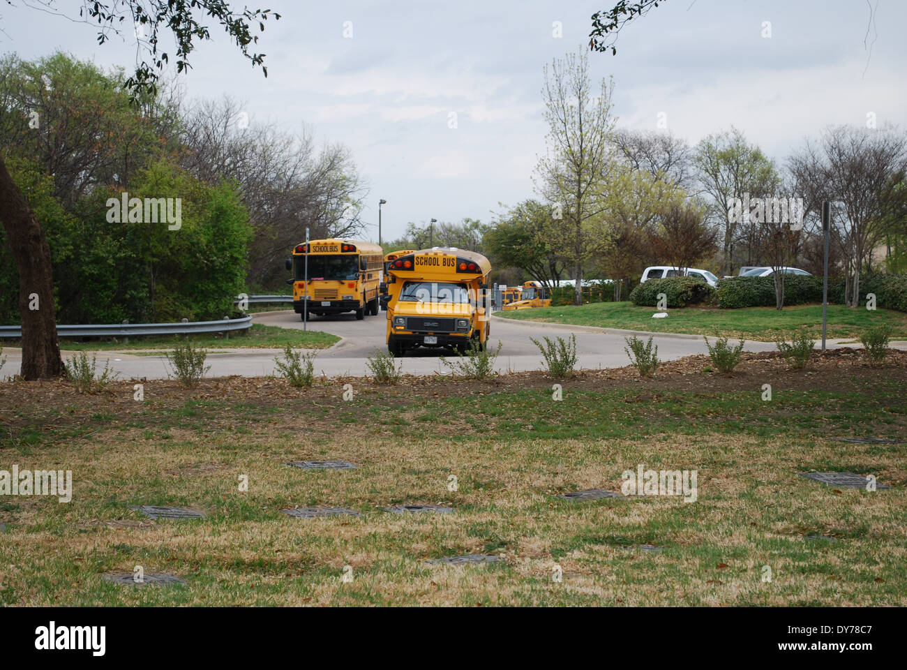Yellow school buses leave a bus barn for the after noon trip from ...