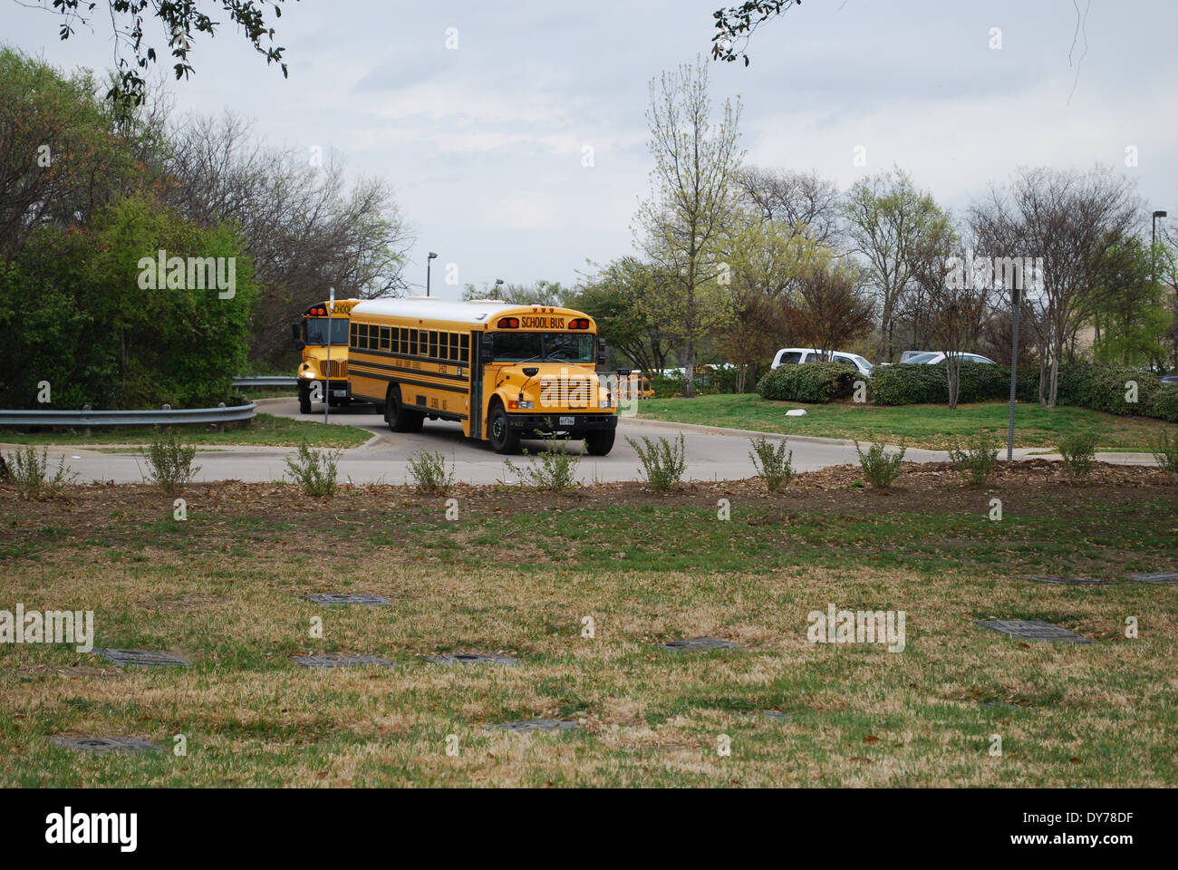 Yellow school buses leave a bus barn for the after noon trip from ...