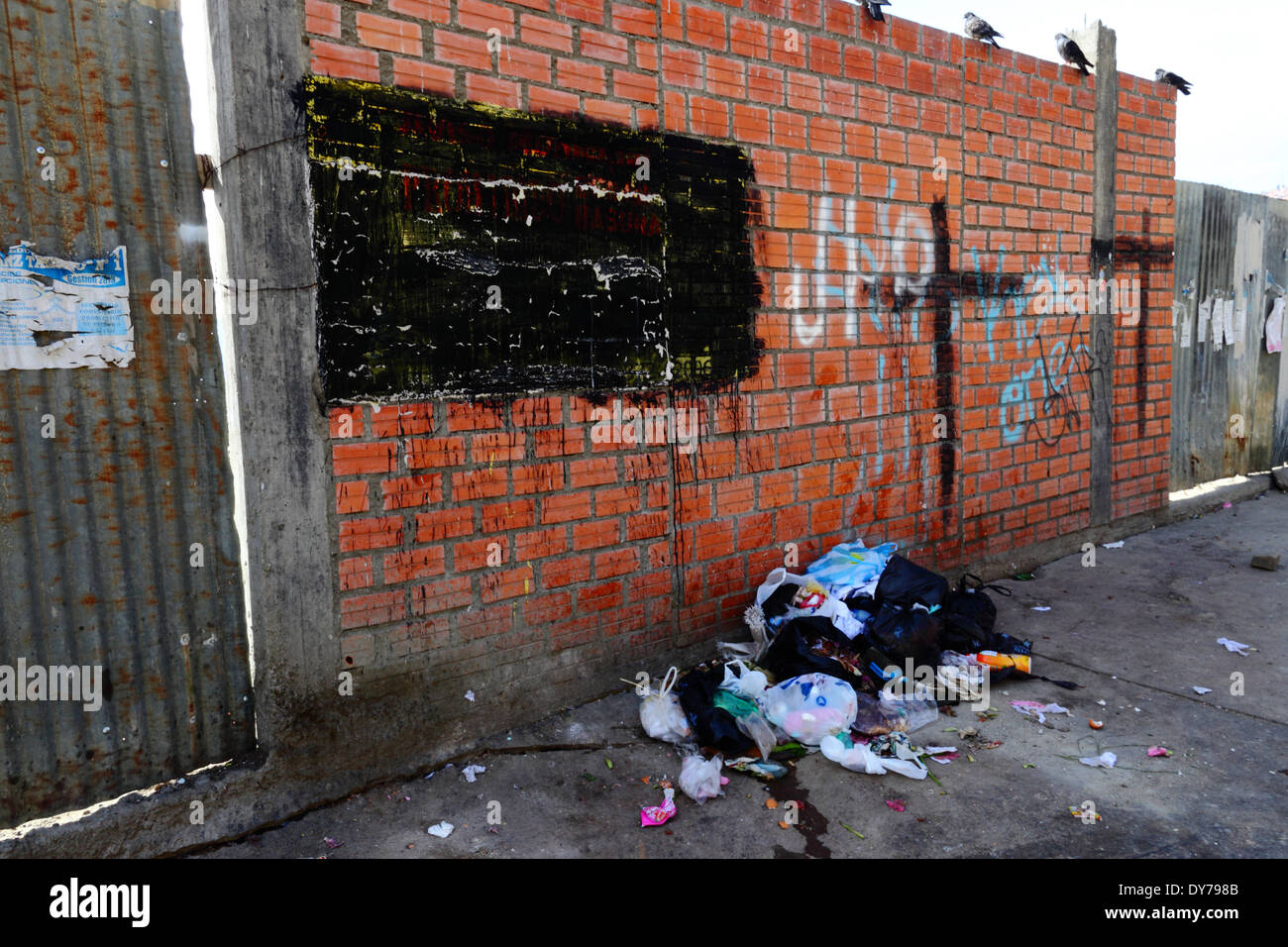 Rubbish dumped on street. Writing on wall telling people not to dump ...