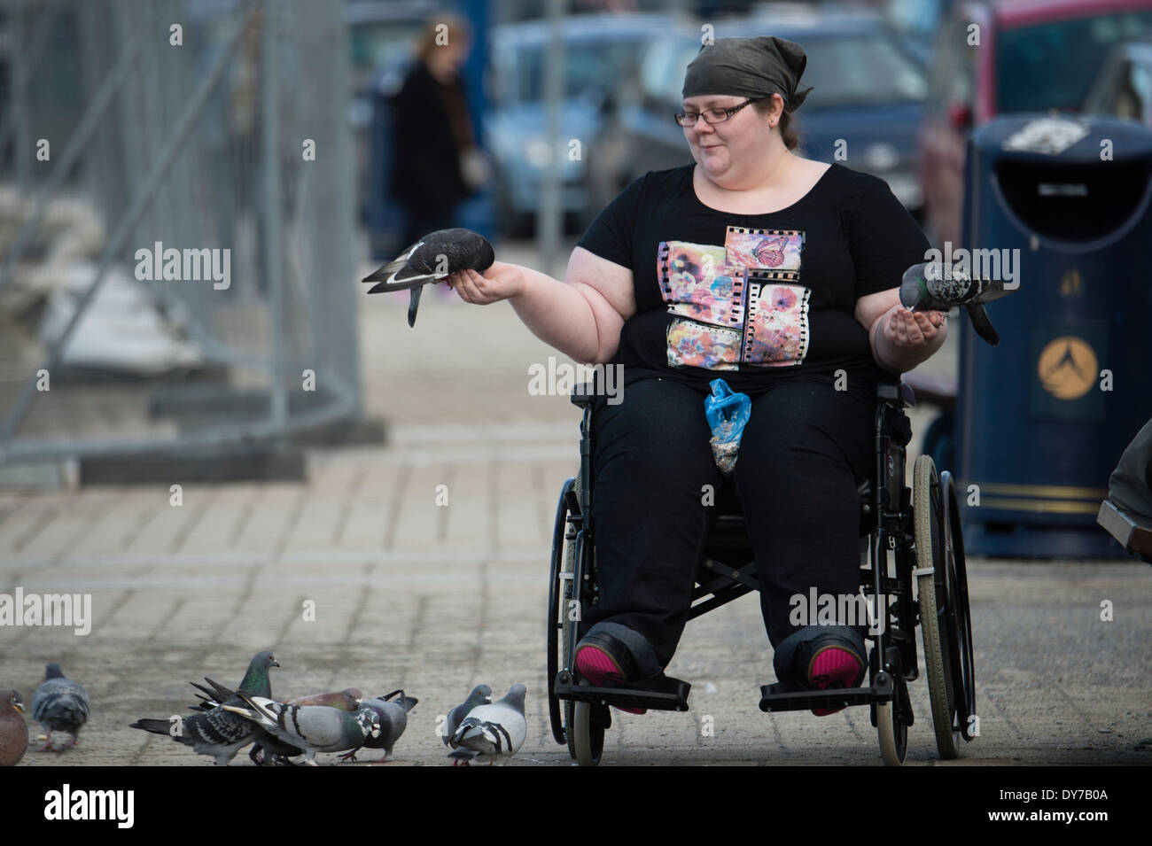 A disabled woman in a wheelchair feeding pigeons, UK Stock Photo - Alamy