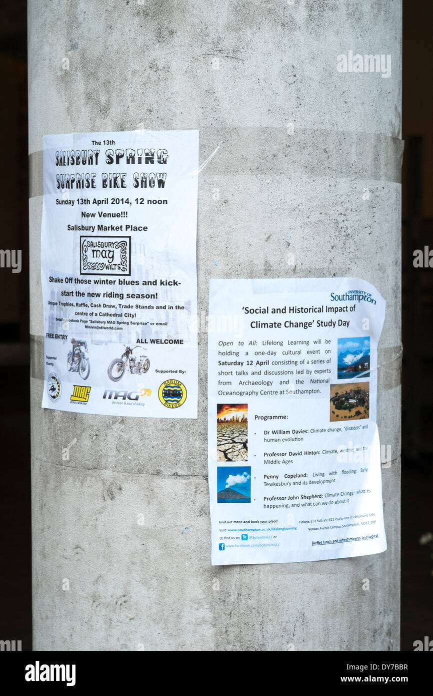 Paper posters advertising local events taped to a circular stone pillar ...