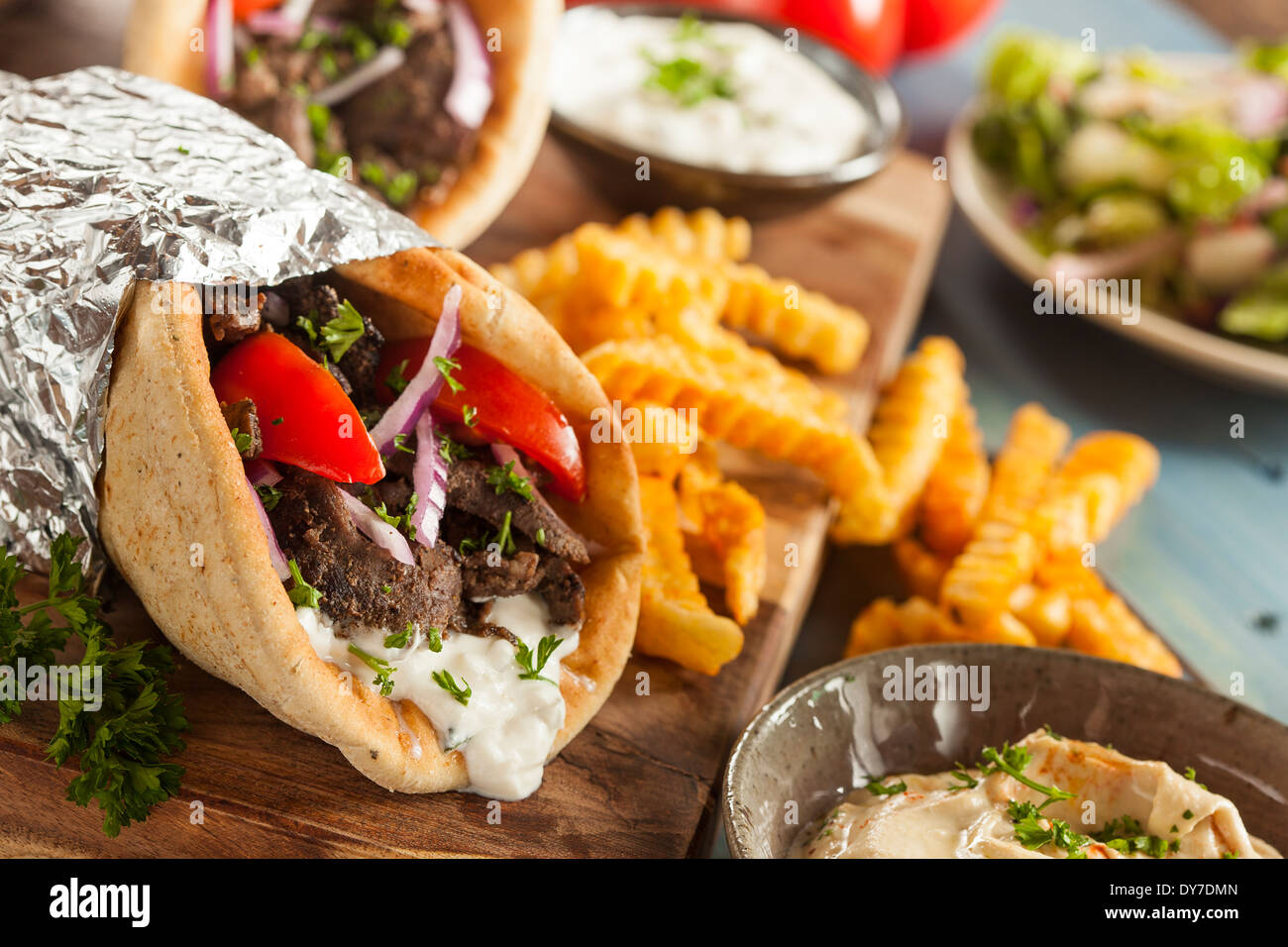 Homemade Meat Gyro with Tzatziki Sauce, tomatos and French Fries Stock ...