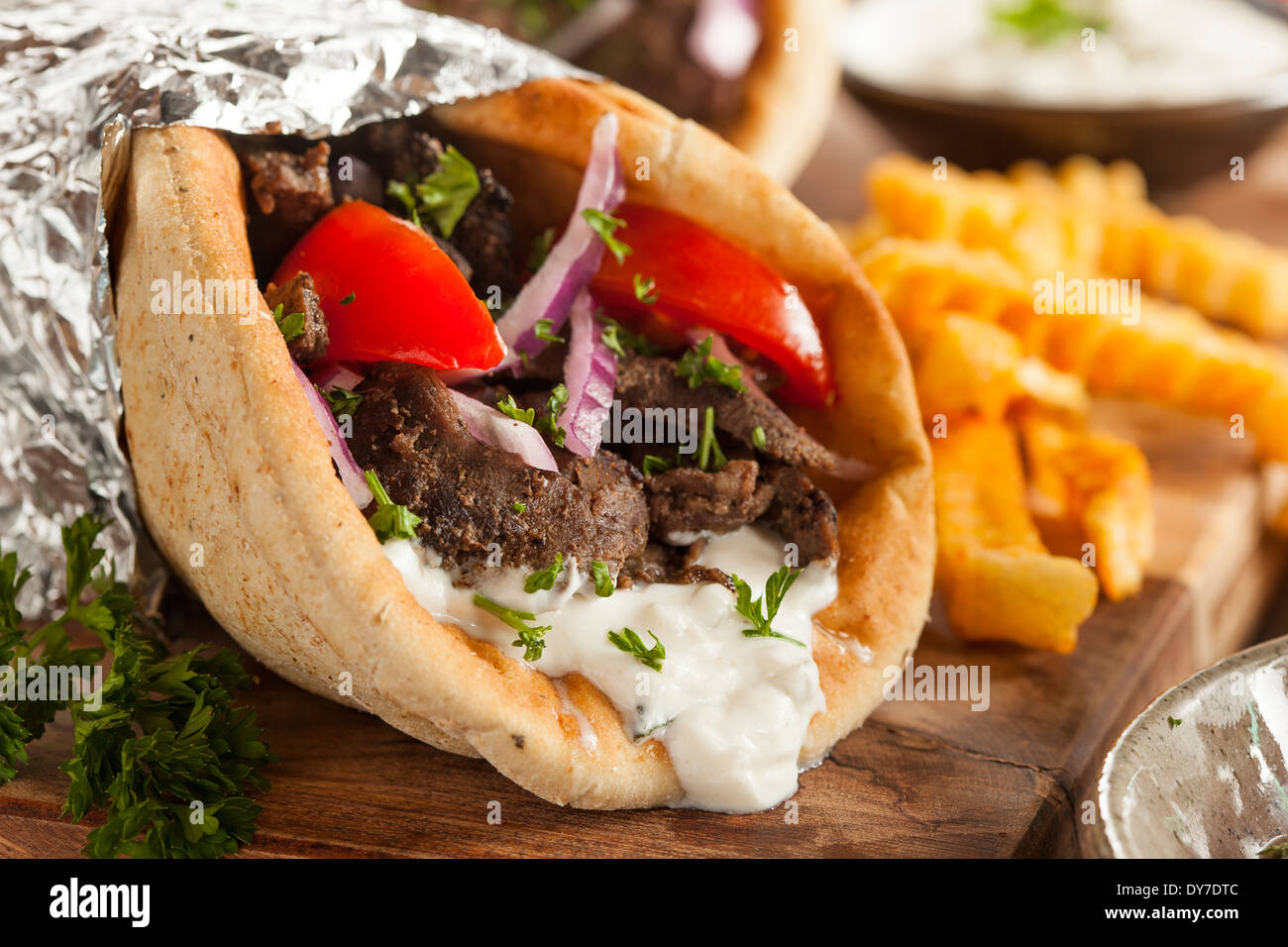 Homemade Meat Gyro with Tzatziki Sauce, tomatos and French Fries Stock ...