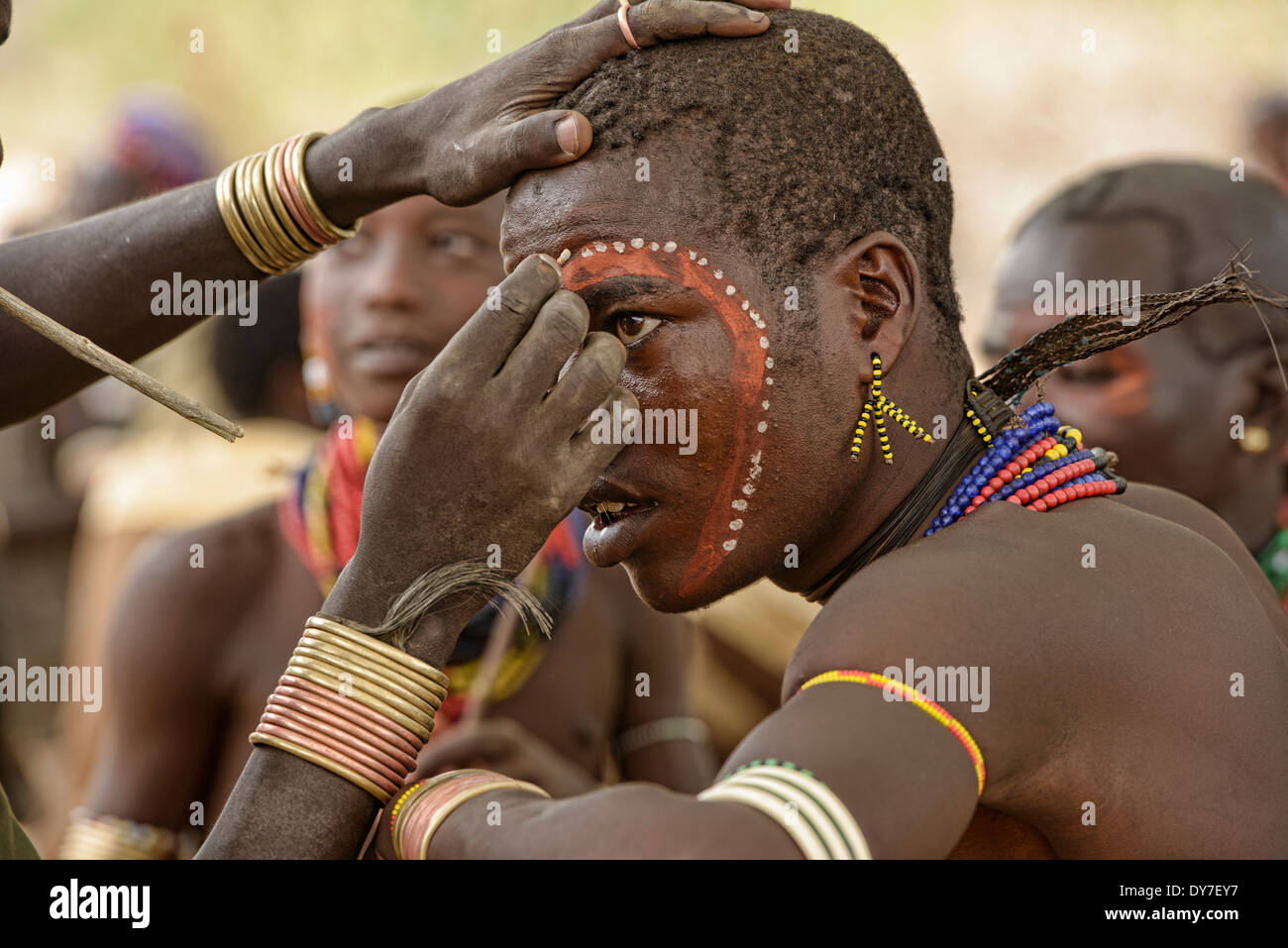Young Hamer men painting their faces at a bull jumping ceremony in the ...