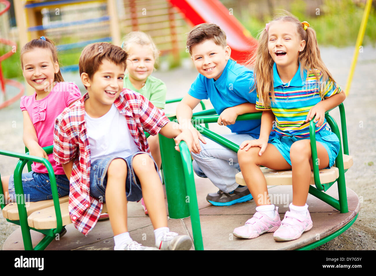 Image of joyful friends having fun on carousel outdoors Stock Photo - Alamy