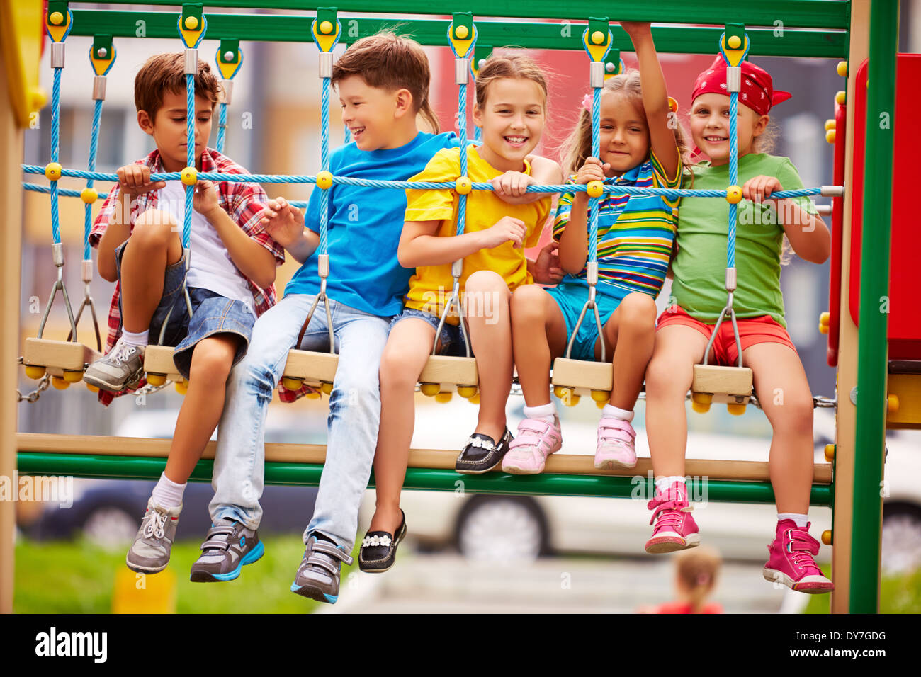 Happy friends having fun on swing on playground Stock Photo - Alamy