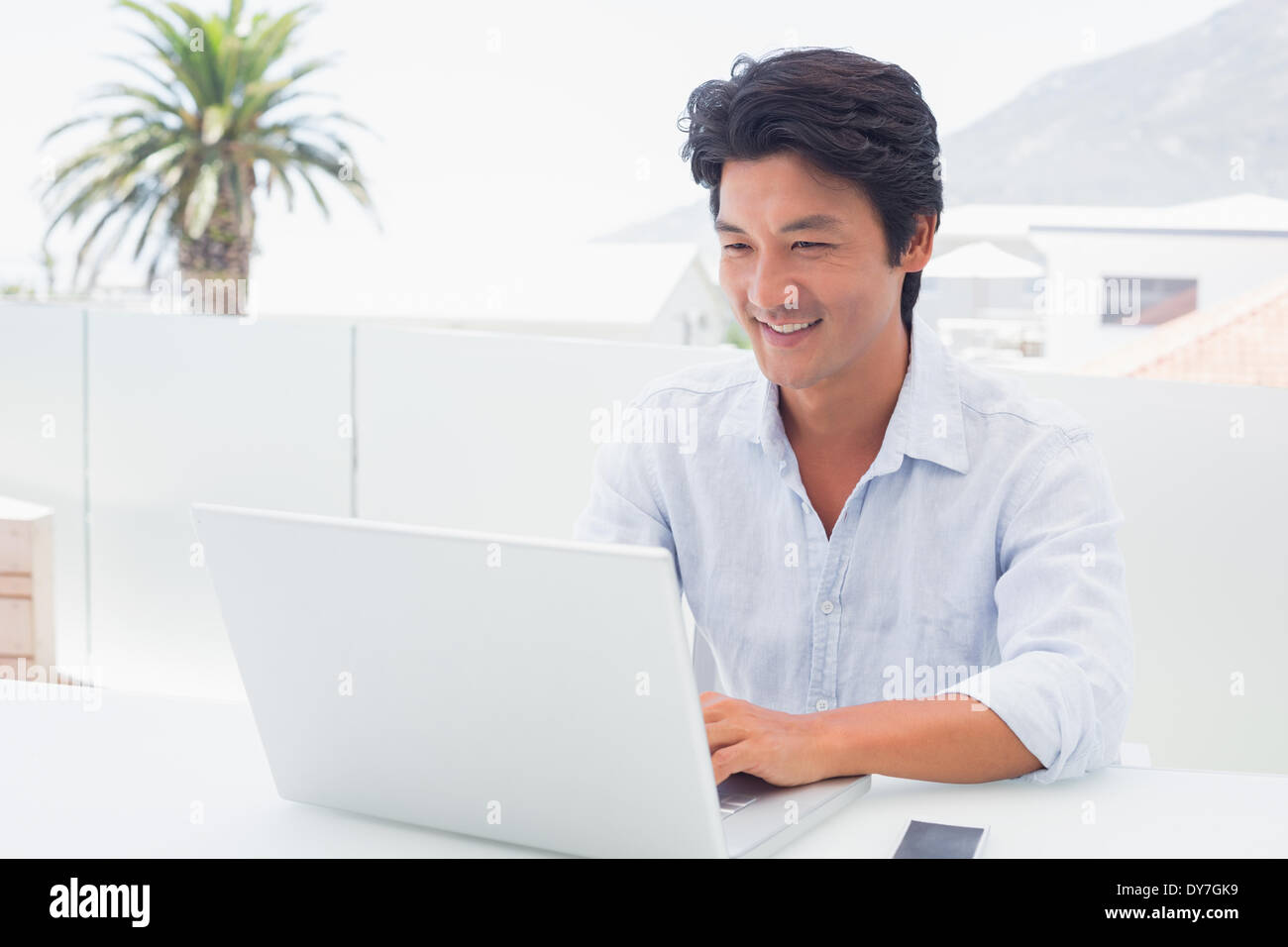 Handsome smiling man using laptop in his bed in bright bedroom Stock ...